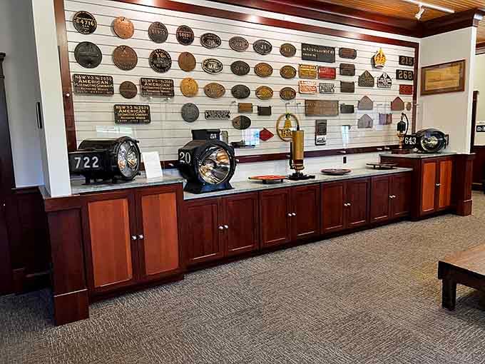 A wall of railroad builder plates, each one a tiny biography of a machine that moved the world.