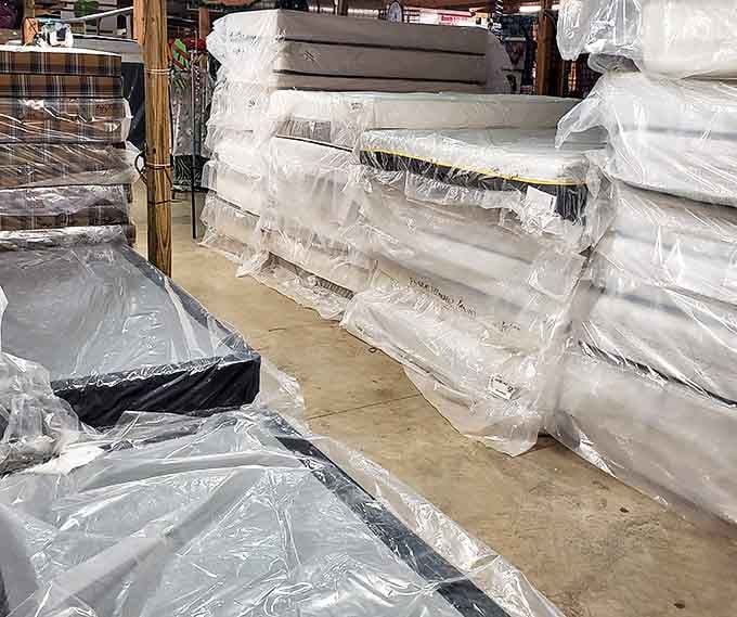 A wall of mattresses wrapped and ready, because even bargain hunters deserve a good night's sleep afterward.