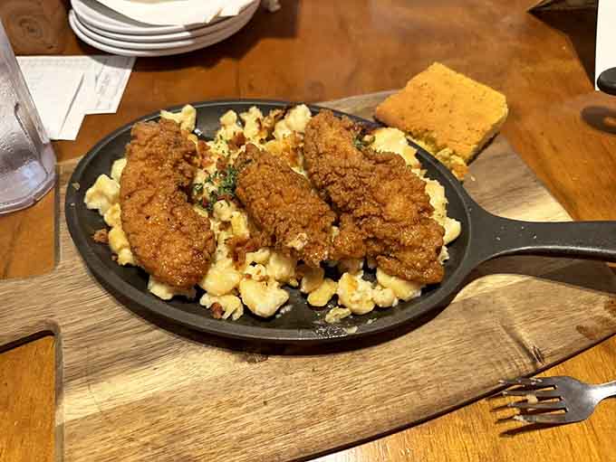 Honey chicken tenders on white baked mac n' cheese with bacon. Someone in that kitchen is clearly a genius.