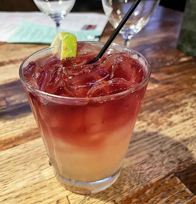 That gorgeous layered cocktail isn't just pretty. It's the kind of drink that makes you slow down and stay.