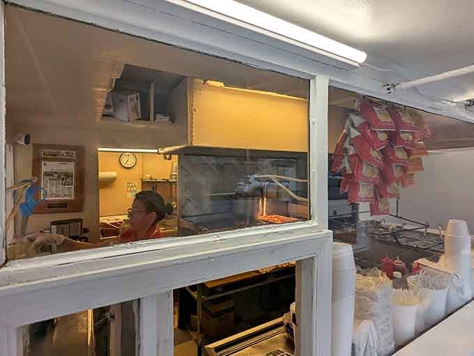 Through that service window, real cooking is happening. The warm kitchen glow behind the glass tells you something good is on its way.