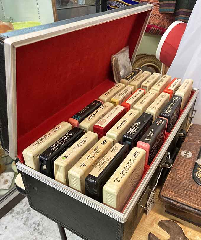 A red-lined carrying case full of 8-track tapes, including Hank Williams Jr., Dolly Parton, and Charlie Rich. Your road trip playlist, sorted.