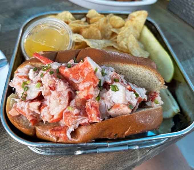That lobster roll is piled so generously it's practically a statement. Maine lobster on a toasted bun, served with chips and a pickle.