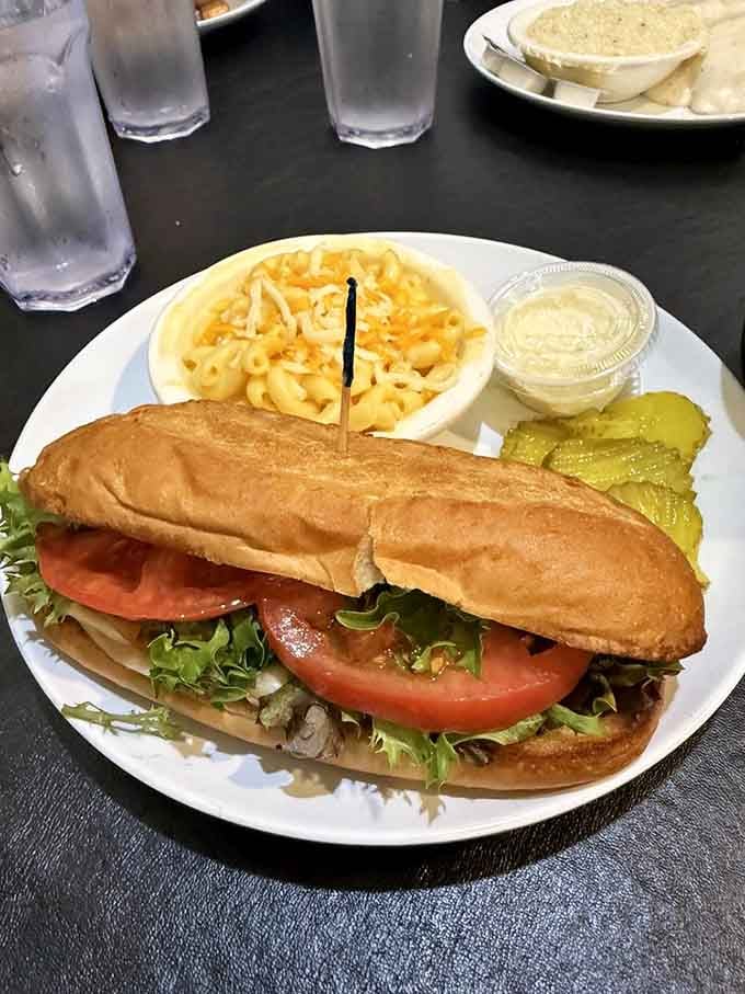 A hearty sub sandwich with fresh tomatoes, lettuce, and mac and cheese on the side, lunch never looked so good.