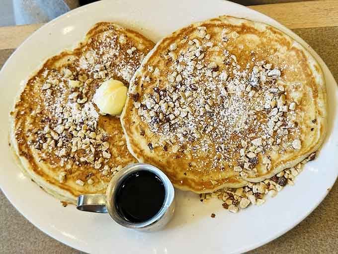 Pancakes topped with crushed nuts and powdered sugar, because sometimes you need breakfast to feel like dessert.