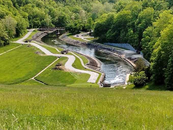 The spillway below the dam rushes through a green valley that looks straight out of a nature documentary.