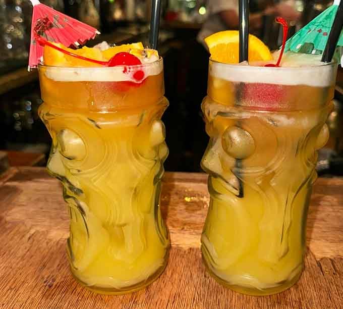 Two tiki-style cocktails dressed with orange slices, cherries, and tiny umbrellas. Dinner hasn't even started and the evening is already going well.