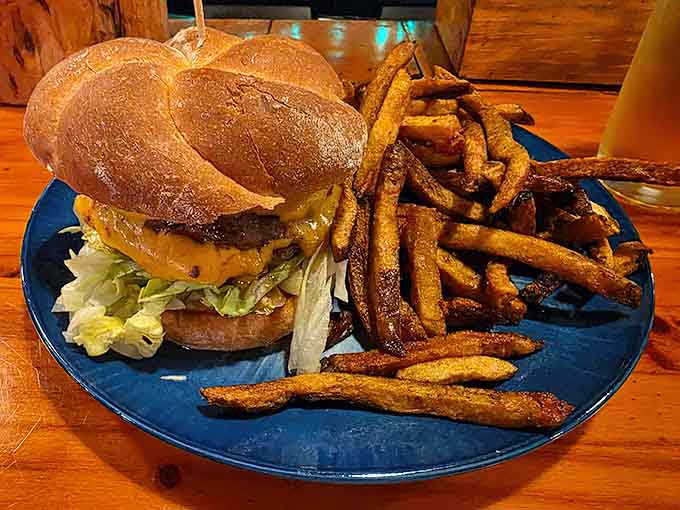 A burger stacked with confidence, sitting next to fries that clearly graduated at the top of their class.
