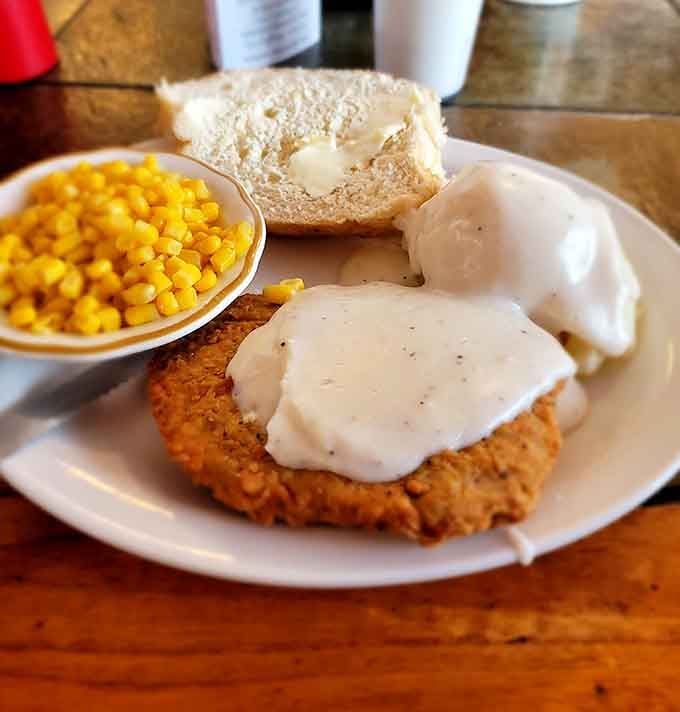 Country fried steak smothered in white gravy with corn on the side. Wisconsin comfort food at its finest.