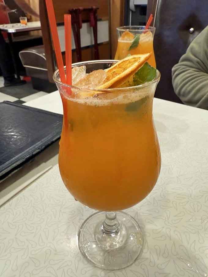 A Peach Arnold Palmer mocktail that looks like sunshine decided to show up in a hurricane glass.