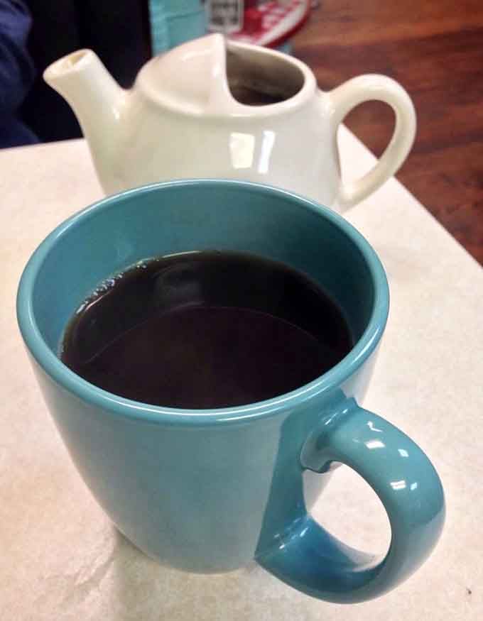 A turquoise mug of hot coffee with a little pot on the side, because some mornings need backup.