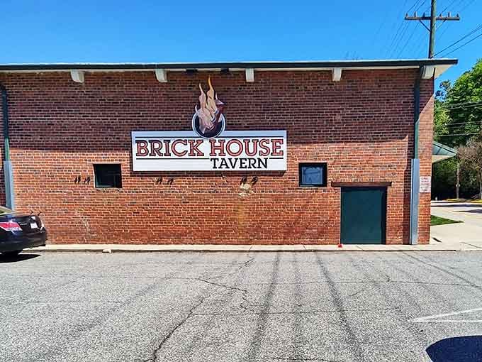 That flaming logo on weathered brick at Brick House Tavern is the universal signal for cold drinks and no-nonsense good times.