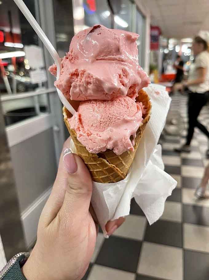 Three scoops of strawberry ice cream in a hand-rolled waffle cone. Go ahead, try eating this gracefully.