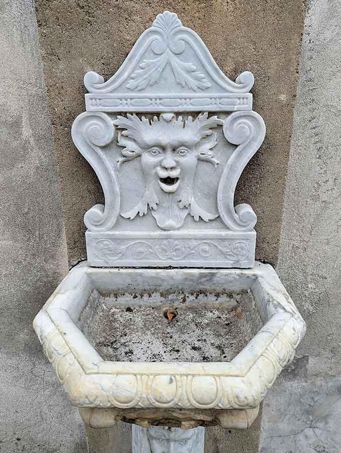 This ornate marble wall fountain with its carved face looks like it has seen some things.