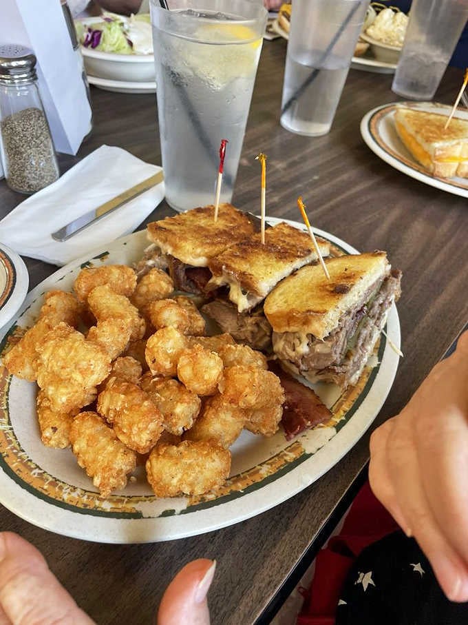 The Trucker Special sandwich arrives loaded and serious, with a mountain of tater tots riding shotgun.