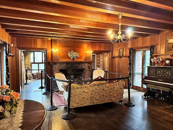 Rich wood paneling, a stone fireplace, and a piano. Gilded Age living rooms did not mess around.