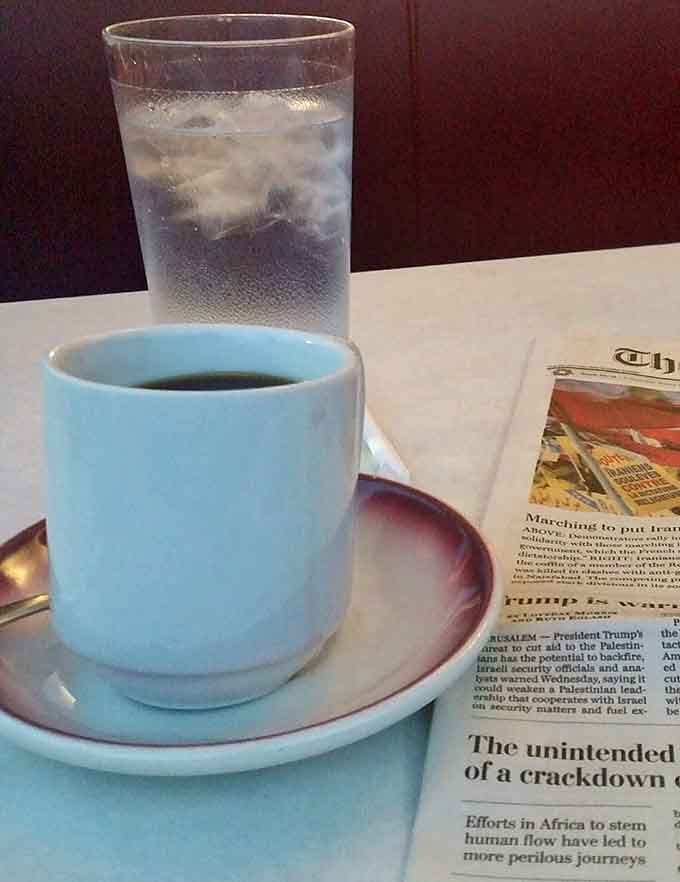 Coffee, a glass of water, and a newspaper. Somewhere, a philosopher is nodding in quiet approval.