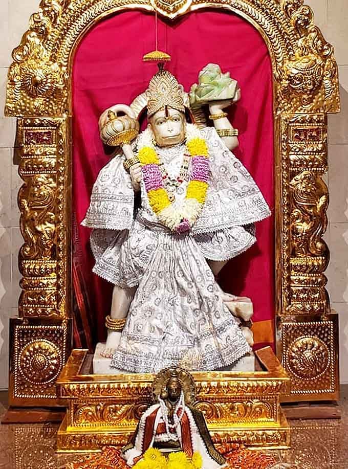 Dressed in white and gold, this Hanuman shrine radiates a calm, powerful presence that stops you mid-step.
