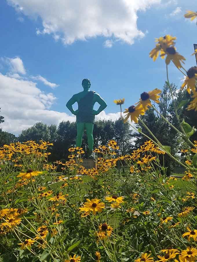 Black-eyed Susans frame the Giant against a brilliant summer sky, turning a roadside stop into something genuinely painterly.