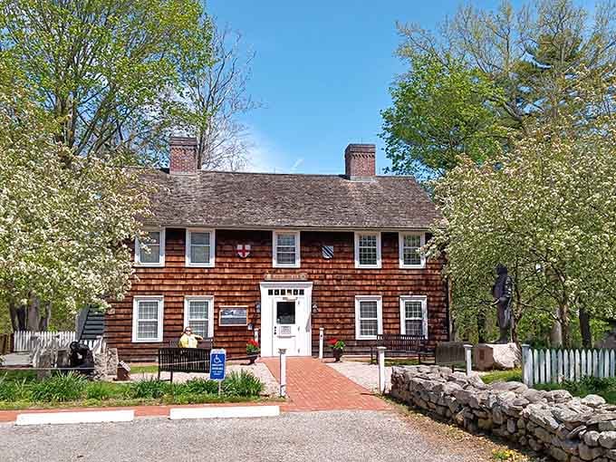 Spring blossoms frame the cedar-shingled Henry Whitfield State Museum like nature itself decided to dress the place up for visitors.