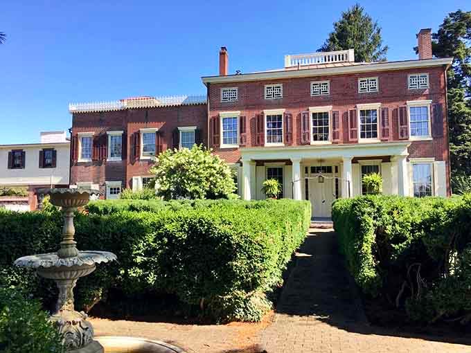 A stone birdbath fountain sits proudly in front of the mansion. Even the garden accessories here have serious curb appeal.