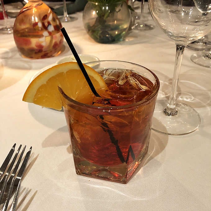 A well-made cocktail on a white tablecloth means the evening is already going exactly the way it should.