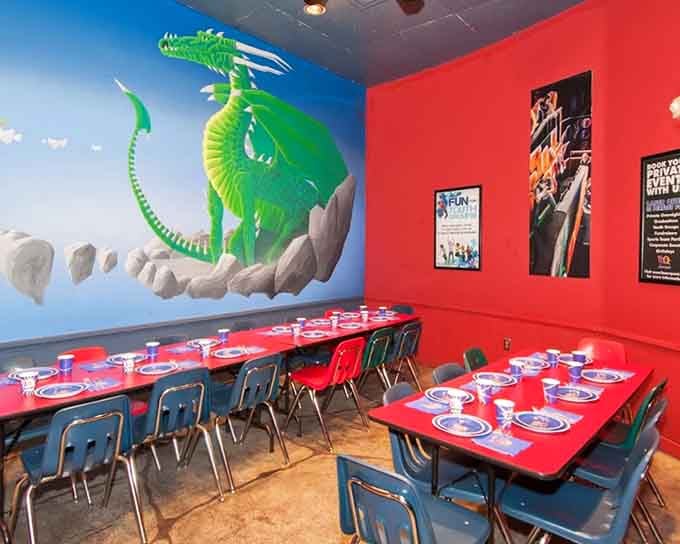 A soaring green dragon mural watching over party tables set and ready, this birthday room means serious business.