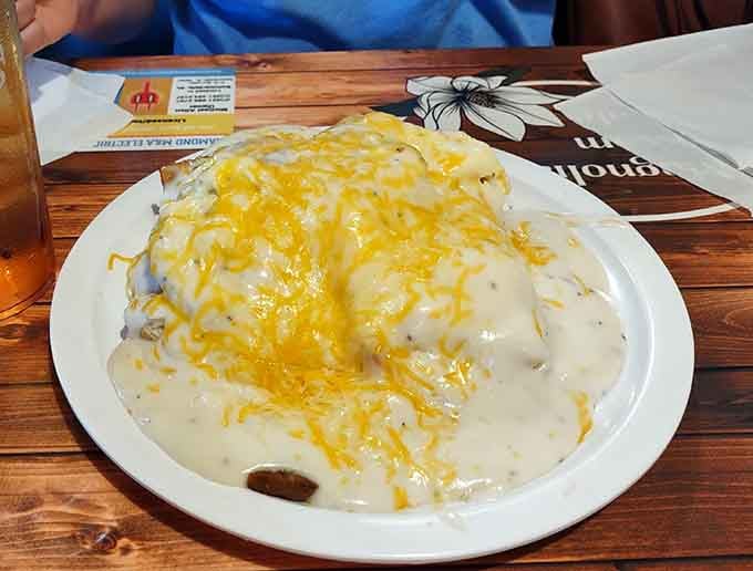 Biscuits drowning in gravy like they're supposed to, served in a skillet because presentation matters even at breakfast.