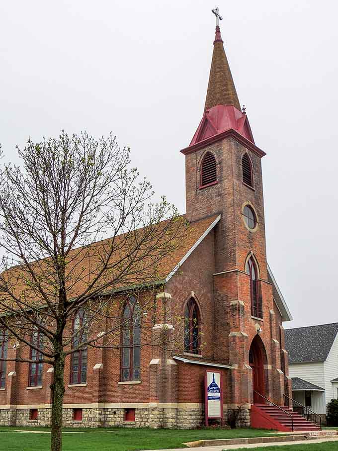 That copper-tipped steeple reaching skyward belongs to Twin City Baptist Church, a red-brick beauty that commands quiet respect on even the grayest Wisconsin morning.