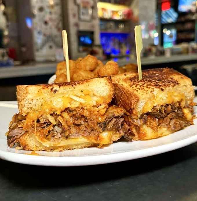 That short rib grilled cheese, stacked high on sourdough with tater tots alongside, is a sandwich that means serious business.