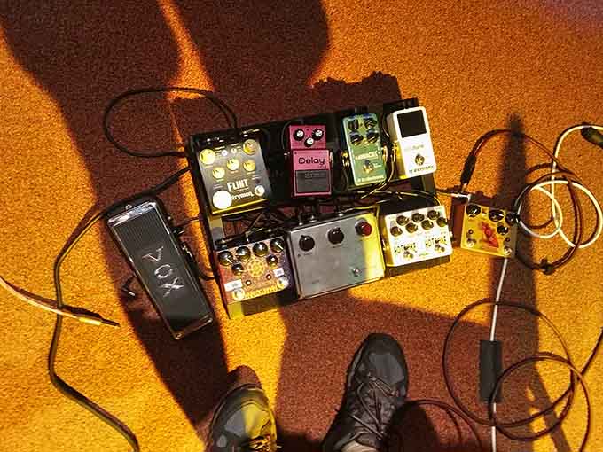A pedalboard full of effects sitting on that famous carpet. Even the floor here has seen more history than most stages.