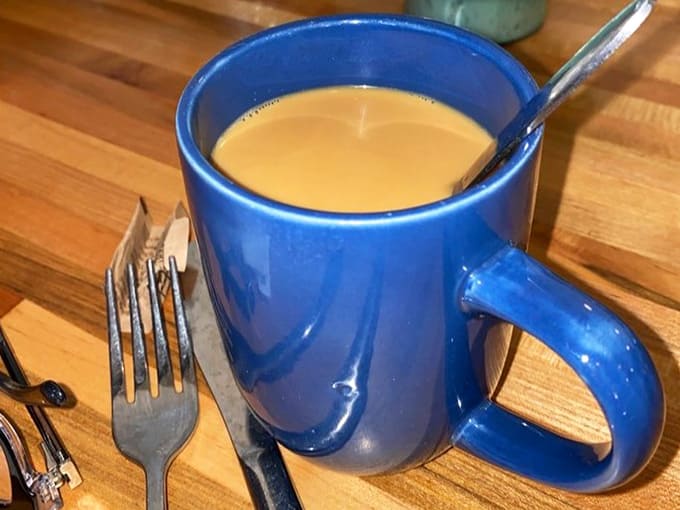 That blue mug holds liquid motivation, the kind that makes early mornings feel like a brilliant life choice.