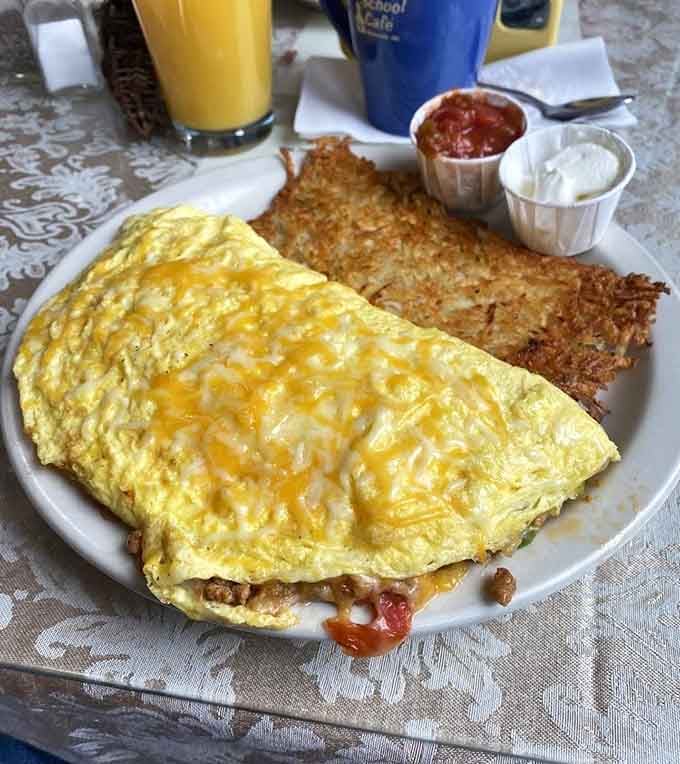 That omelette is melted cheese on top of more good things, served alongside hashbrowns that earned their golden color honestly.
