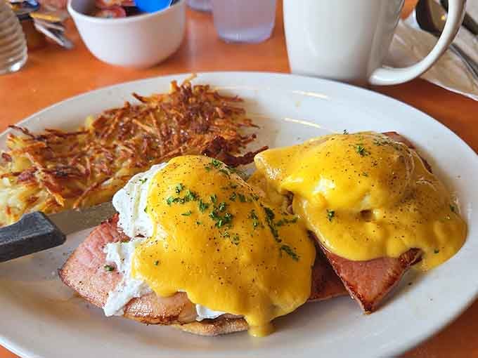Eggs Benedict done right, with hollandaise that flows like liquid gold over perfectly poached eggs and crispy hash browns.