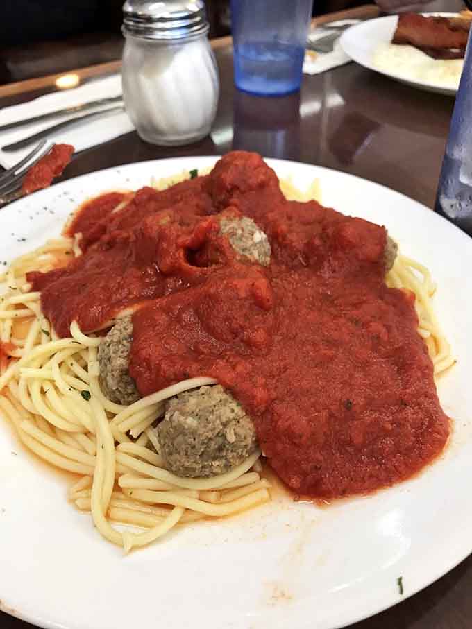 A generous bowl of spaghetti buried under rich red sauce and hearty meatballs. Nonna would nod approvingly at this one.