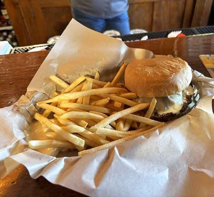 A cheeseburger and fries served in a basket, honest and unfussy, exactly what a saloon burger should be.