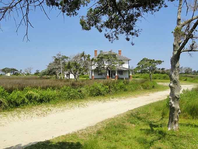 Twin chimneys, a wraparound porch, and a sandy road leading nowhere. This house has serious old-soul energy.