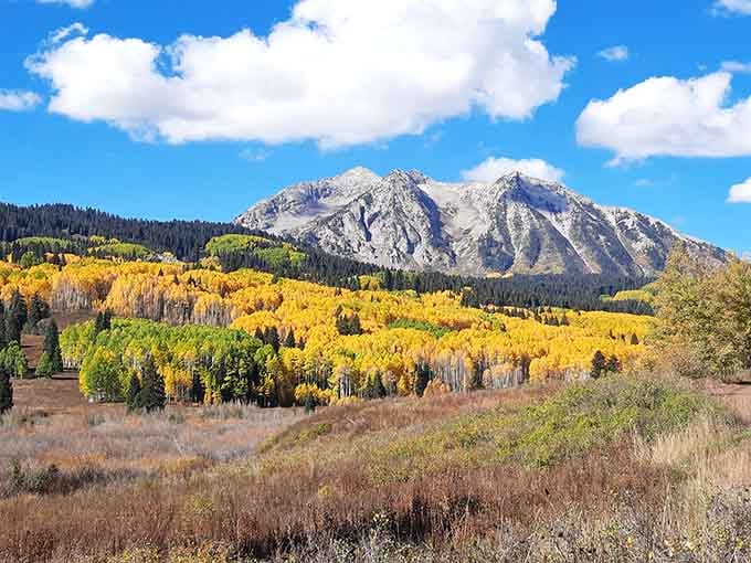 Golden aspens blanket the hillsides below rocky peaks, making fall in this region genuinely unfair to other seasons.