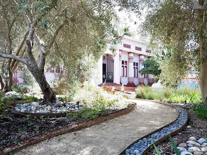 A winding garden path leads you through an olive grove toward the museum, offering a surprisingly tranquil moment before the ancient wonders begin.