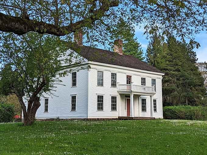 The Bybee-Howell House stands white and dignified beneath old trees, carrying Oregon history in every carefully preserved plank.