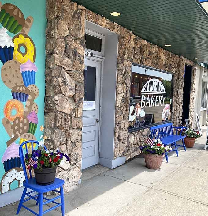 Blue benches, flower pots, and a cheerful mural. Simple Simon Bakery's sidewalk says "stay awhile" without words.