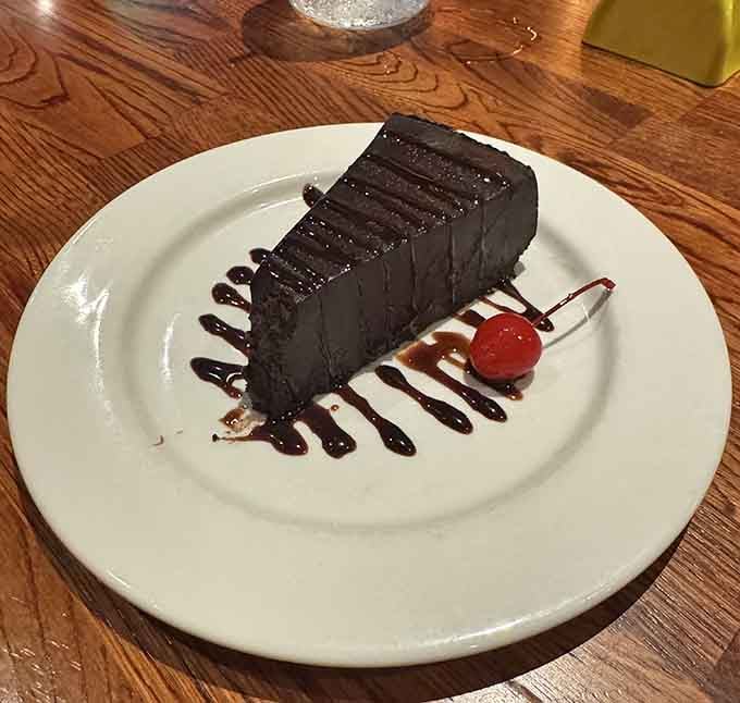 A slice of chocolate cake so serious it deserves its own wanted poster on the wall.