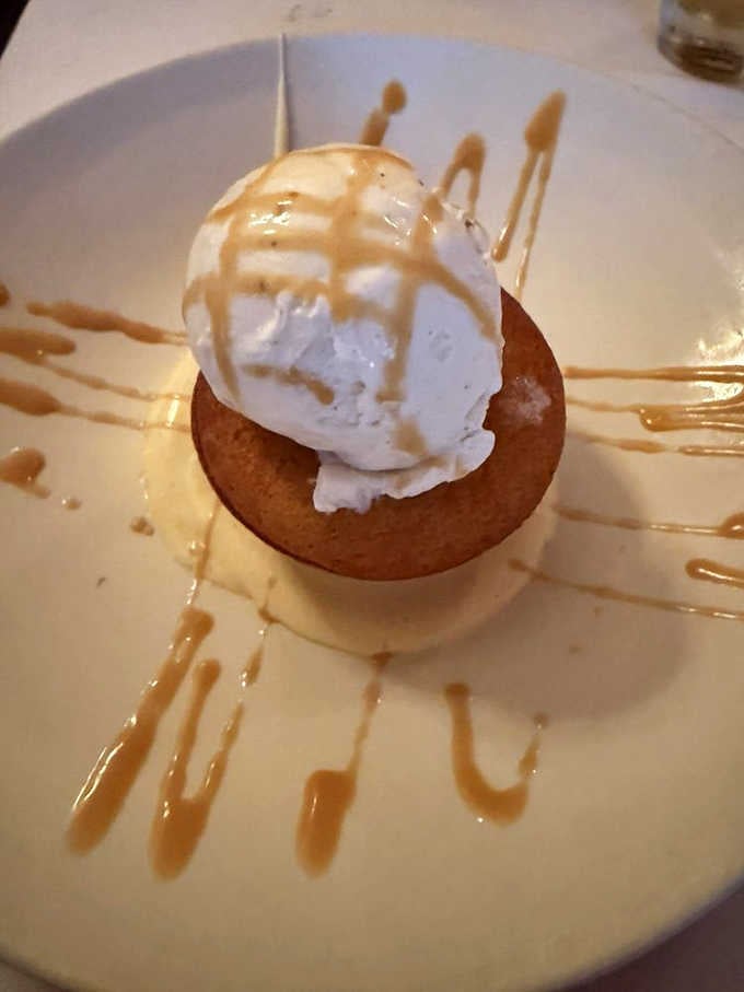 Bourbon Butter Cake topped with ice cream and caramel drizzle, the dessert that makes skipping it feel genuinely irresponsible.