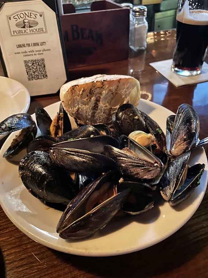 A generous bowl of steamed mussels with crusty bread alongside, the kind of dish that makes you forget everything else.
