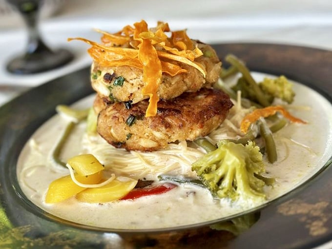Golden crab cakes stacked over angel hair pasta and cream sauce, with vegetables that actually want to be there.