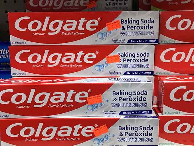 Stacked Colgate boxes lined up like little soldiers of dental duty, reminding you that a bright smile never goes out of style.