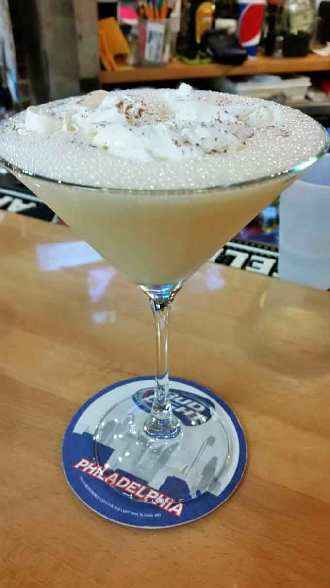 A creamy, whipped martini resting on a Philadelphia coaster, because even your drink knows exactly where it belongs.