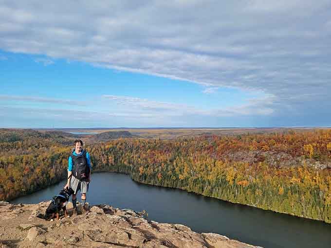 That smile says it all. Cliff-top views, crisp autumn air, a loyal dog, and not a single email in sight.