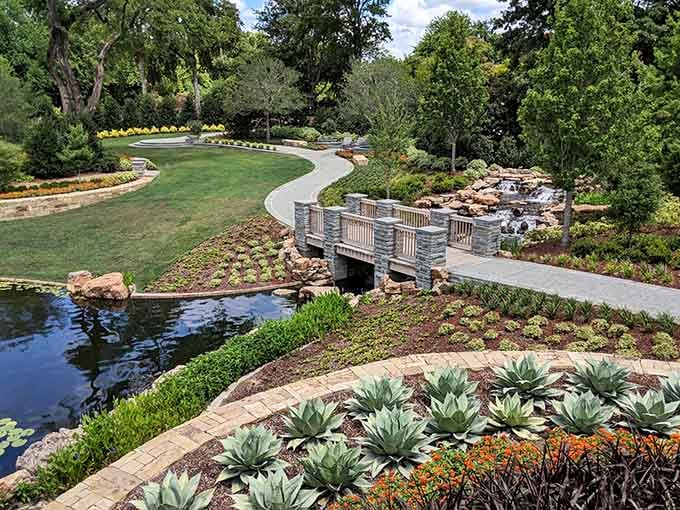 A winding stone bridge over lily pads and a waterfall, because apparently this garden doesn't do ordinary.