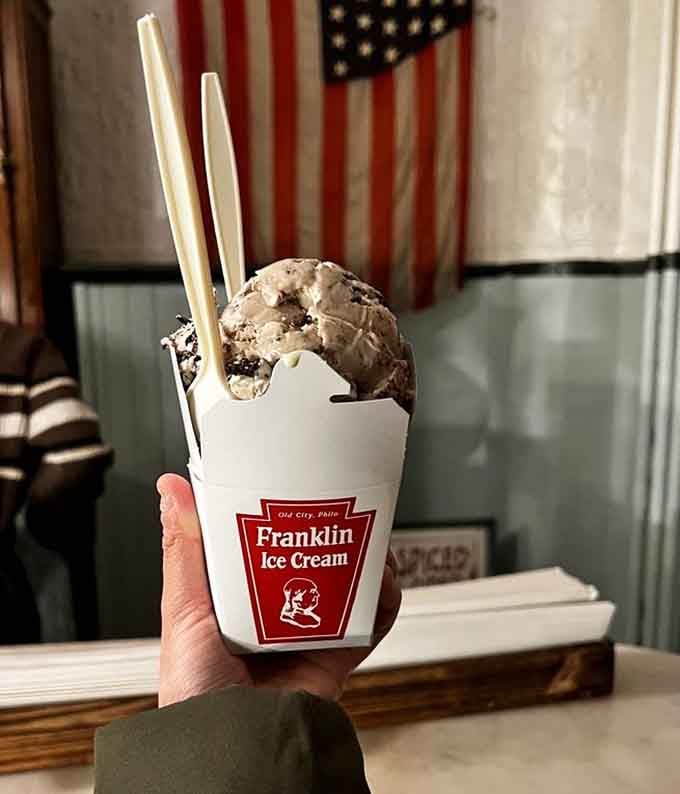 Cookies and cream ice cream held up proudly, with an American flag in the background adding unexpected patriotic flair.